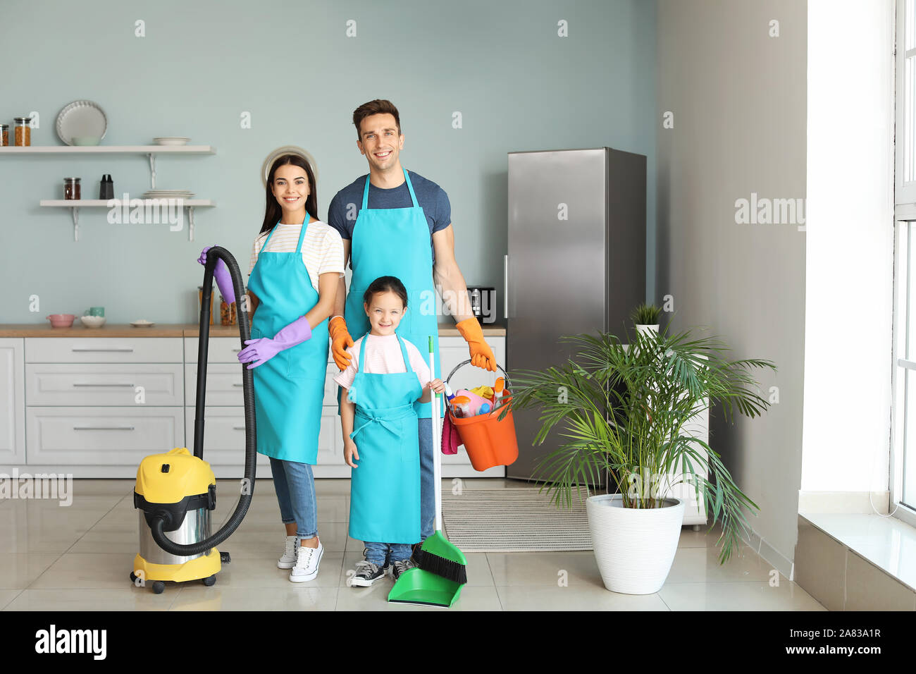 Happy family cleaning kitchen together Stock Photo - Alamy