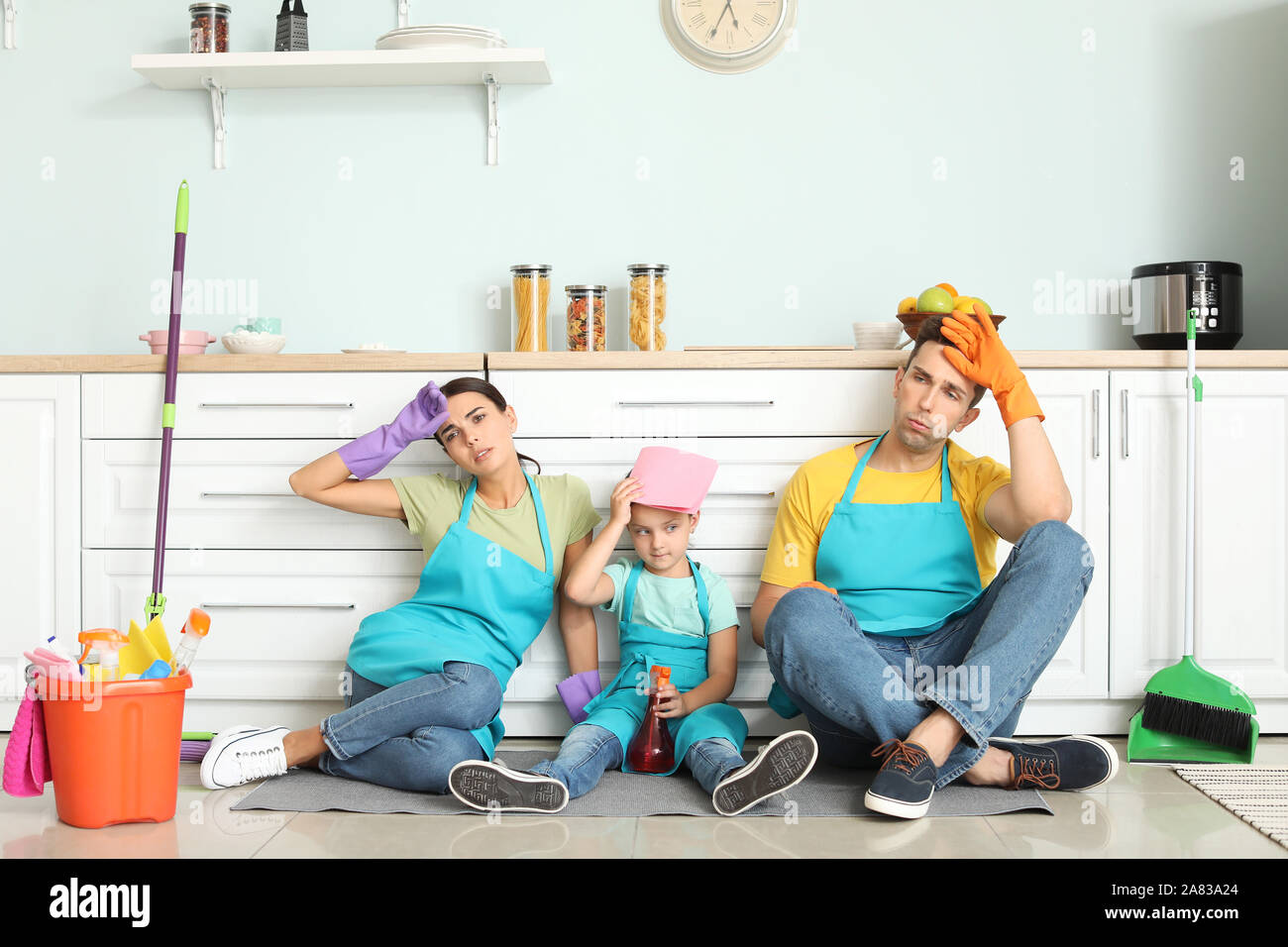 Tired family after cleaning kitchen together Stock Photo - Alamy