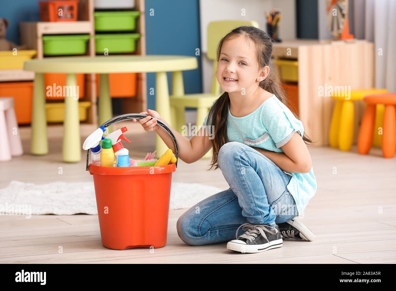 Little girl with cleaning supplies in room Stock Photo - Alamy