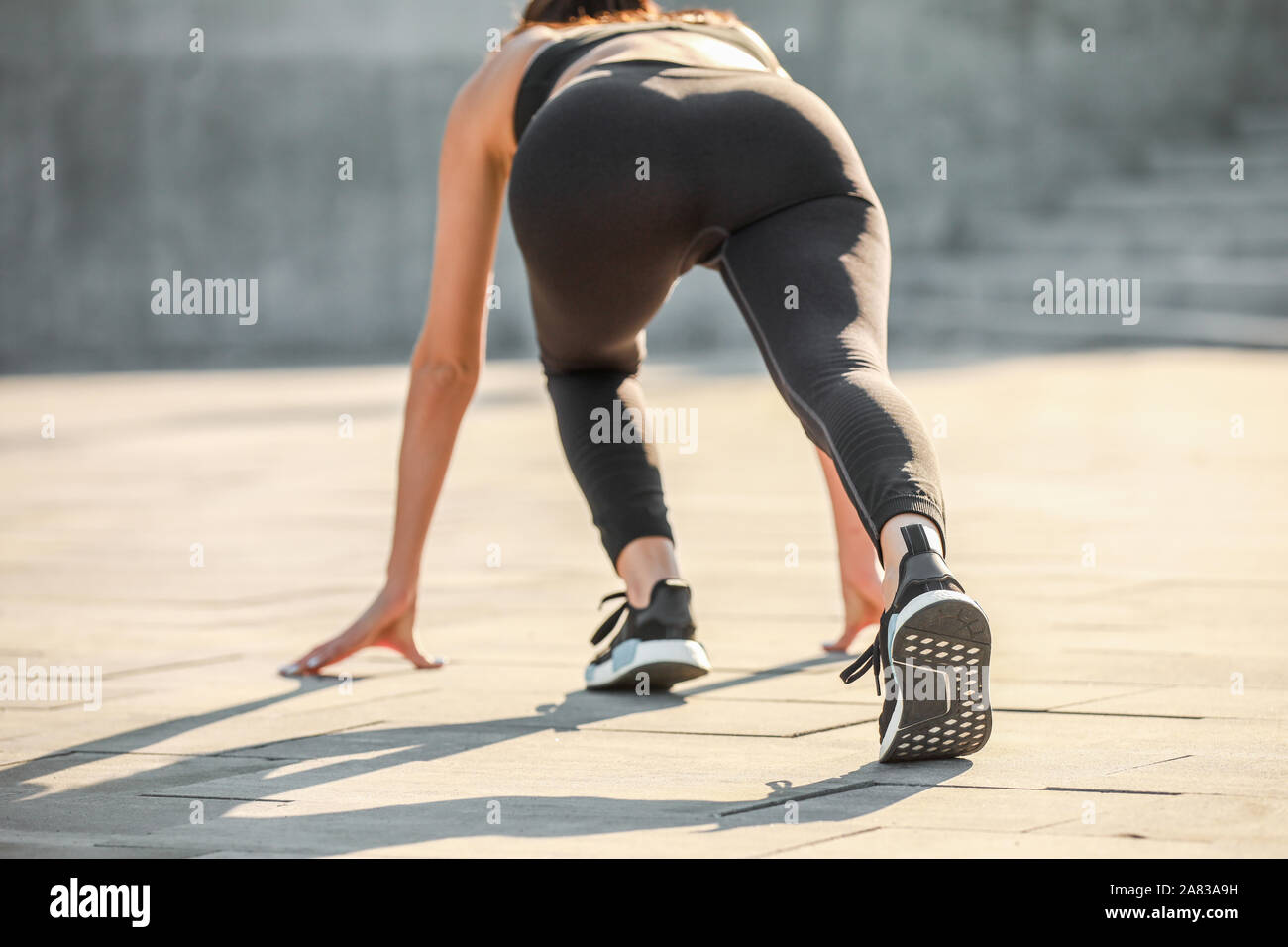Sporty young woman in crouch start position outdoors Stock Photo - Alamy