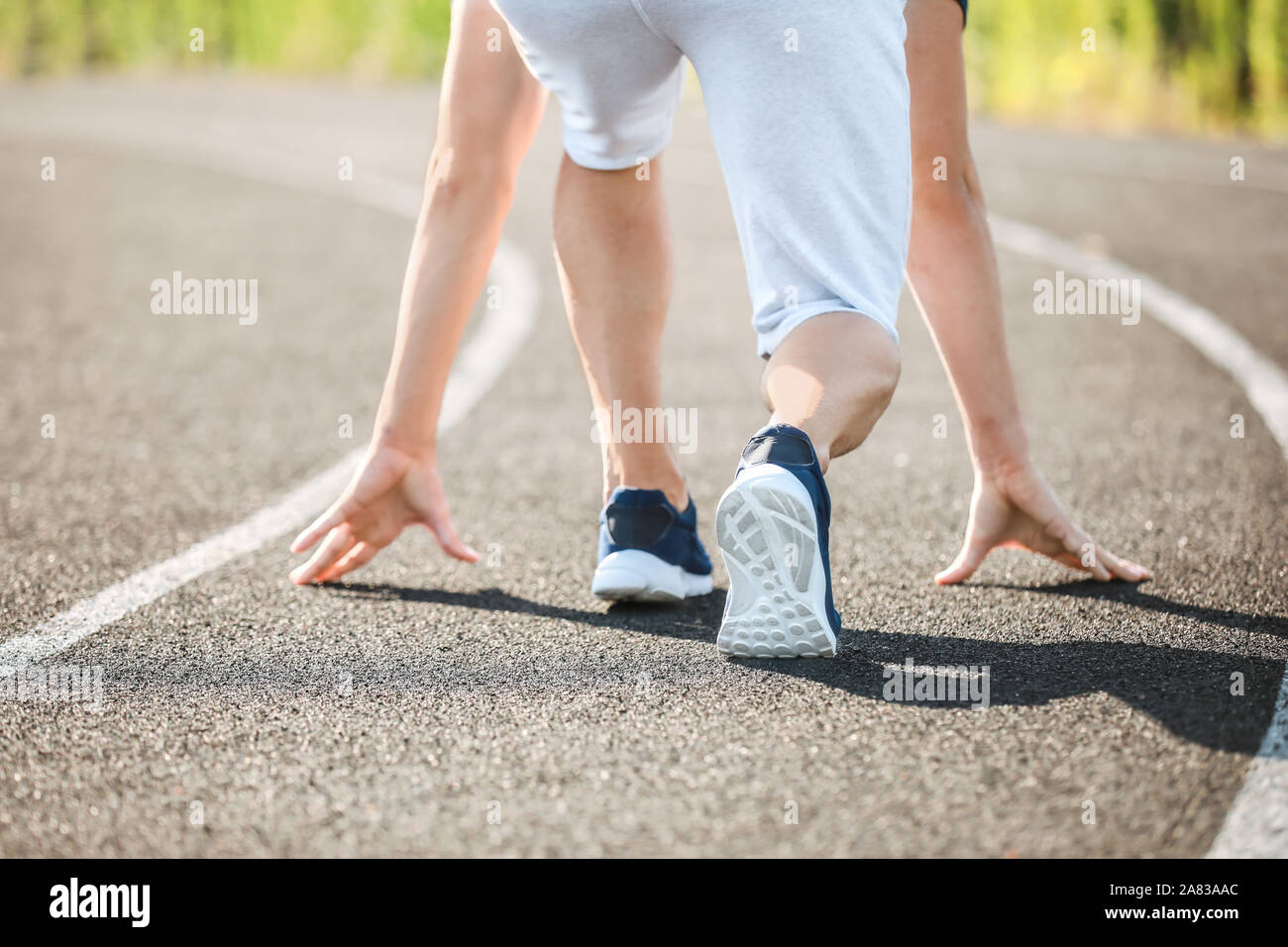 Sporty young man in crouch start position at the stadium Stock Photo ...