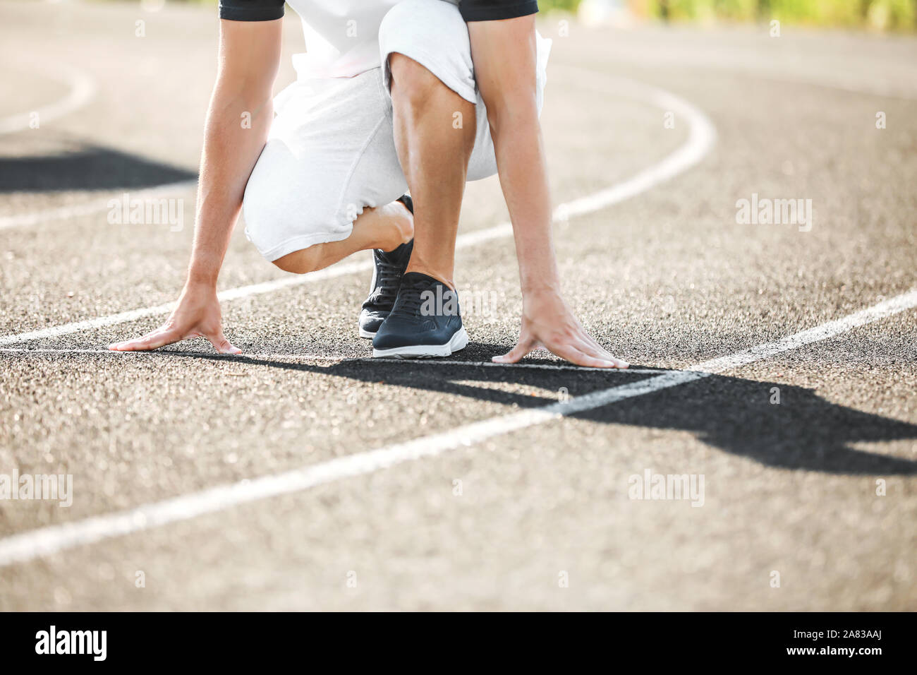Sporty young man in crouch start position at the stadium Stock Photo ...