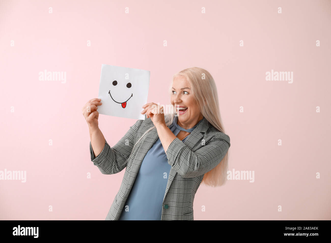 Happy mature woman with emoticon against color background Stock Photo ...