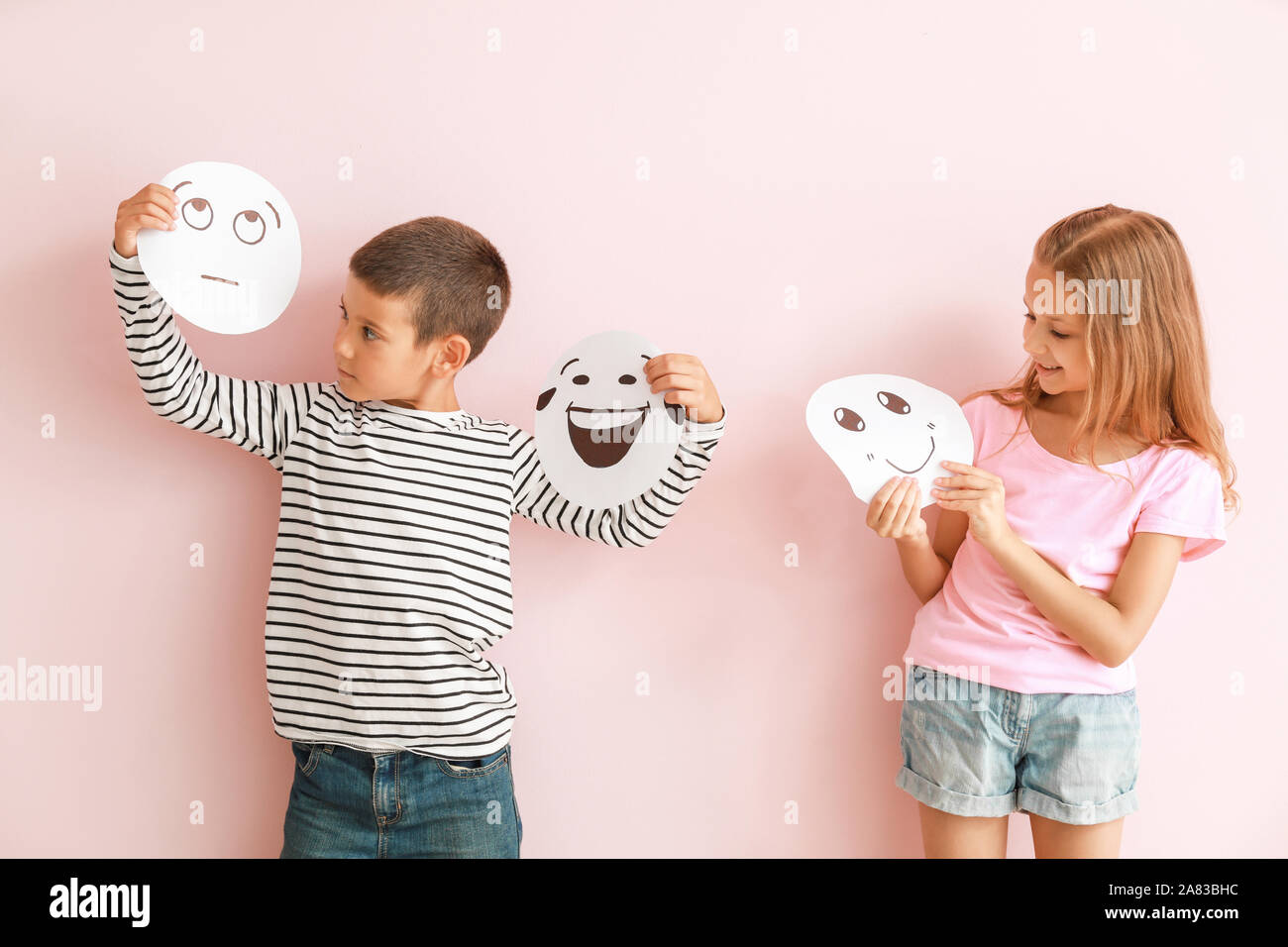 Little children with drawn emoticons on color background Stock Photo ...