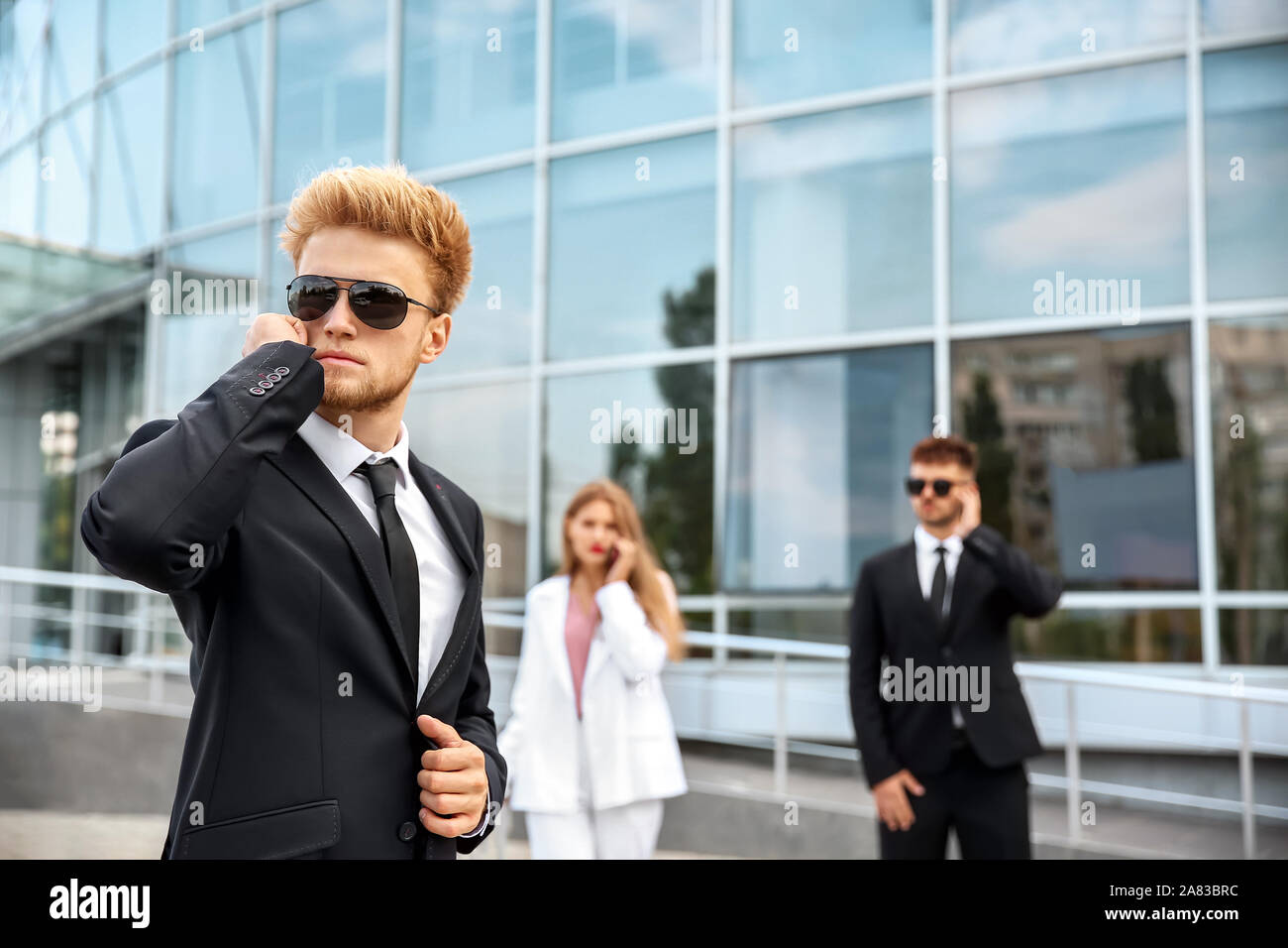 Young celebrity with bodyguards outdoors Stock Photo - Alamy