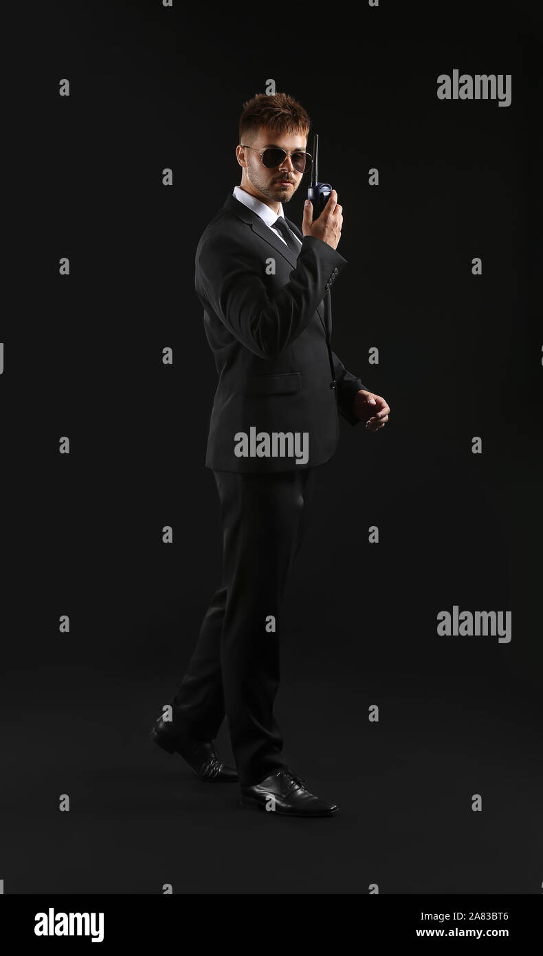 Handsome security guard on dark background Stock Photo - Alamy