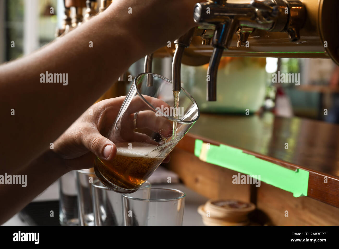 Barman pouring fresh beer in glass, closeup Stock Photo - Alamy