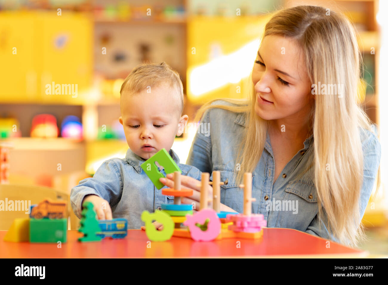 young teacher studying with baby toddler in kindergarten Stock Photo ...