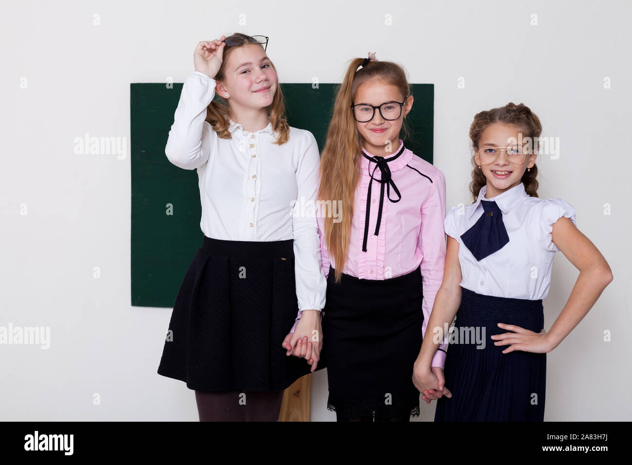 three girls schoolgirl in class at the green board Stock Photo - Alamy