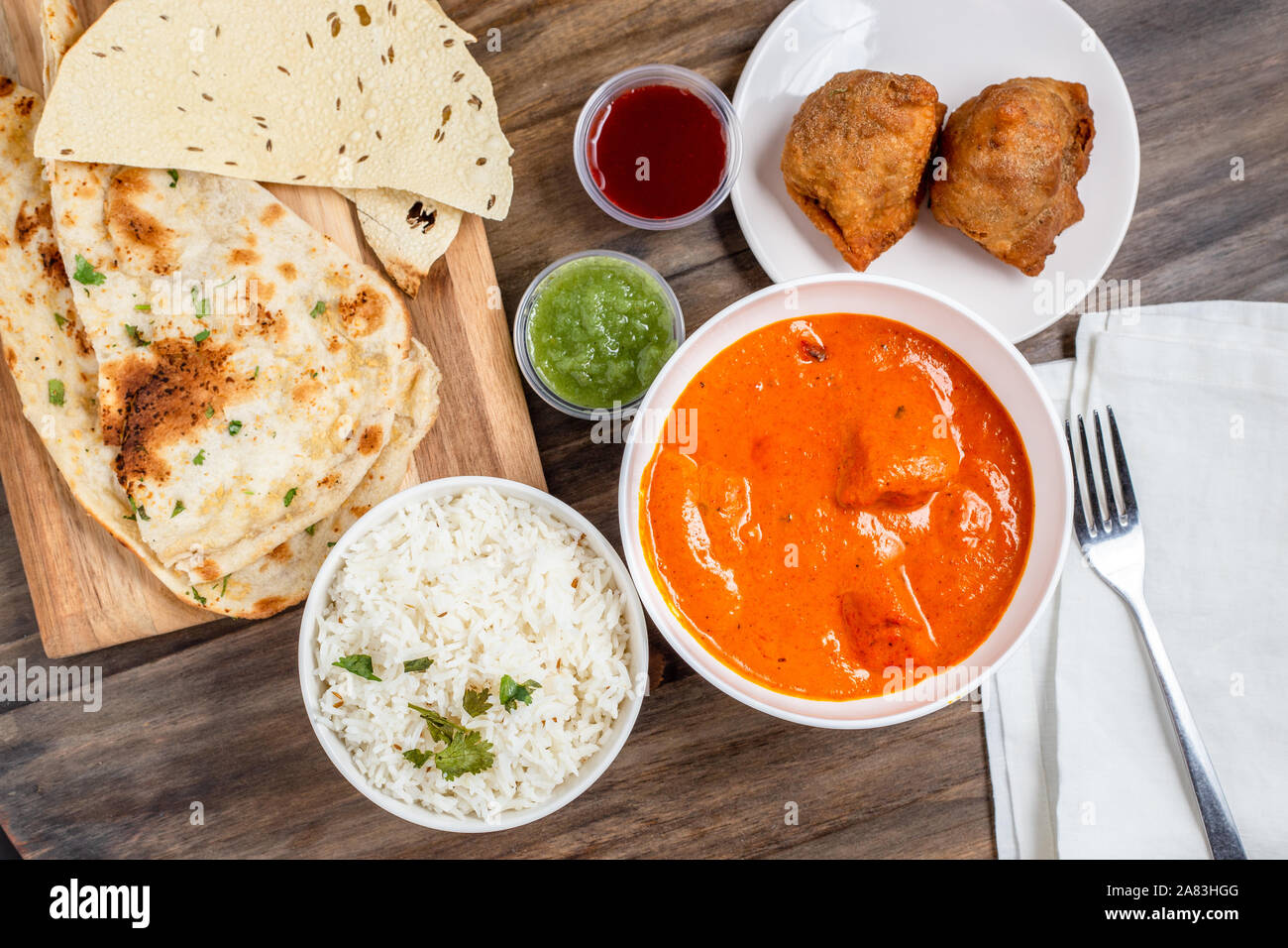 Indian food with chicken tikka masala, samosas, rice, naan and papadum ...