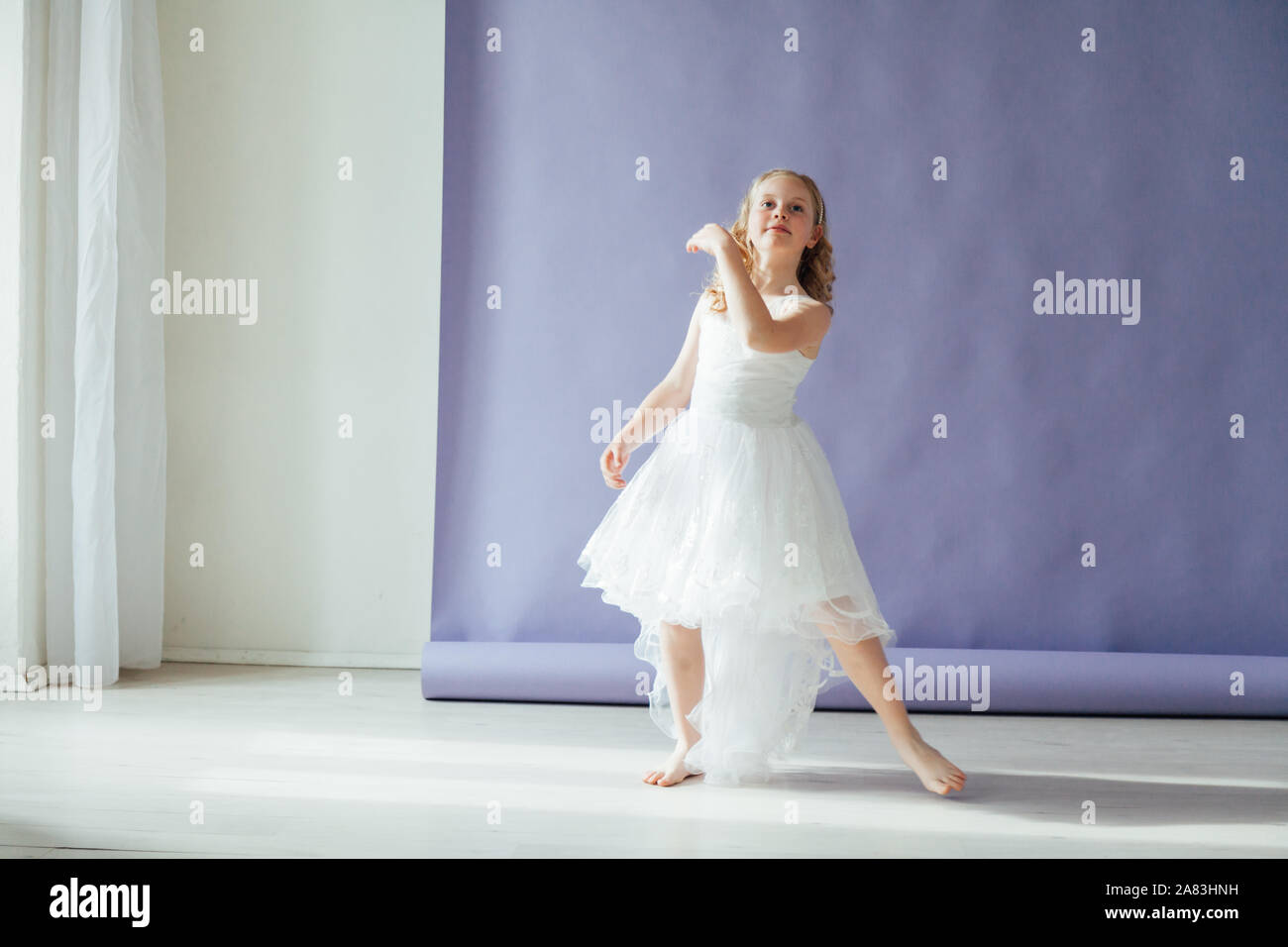 Beautiful girl of 10 years dancing in a white dress Stock Photo - Alamy