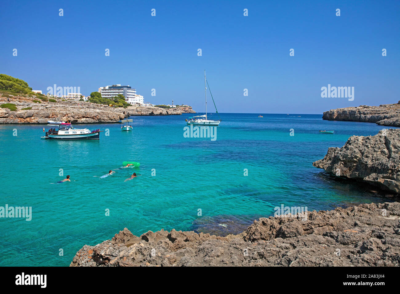 People swimming in the bay of Cala Marcal, bathing beach at Porto Colom ...