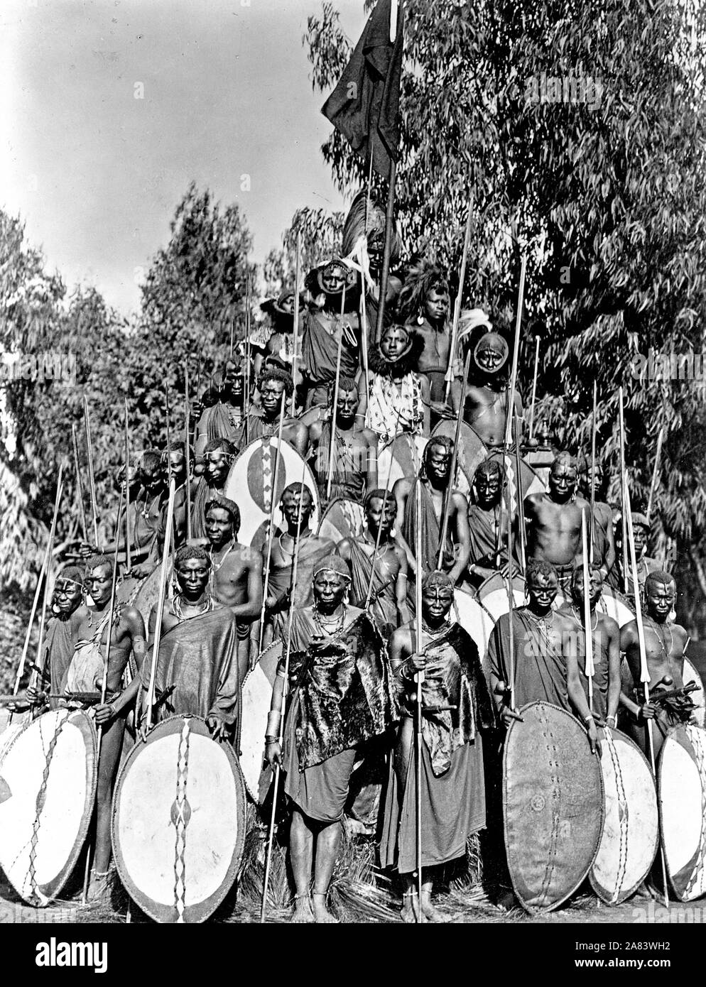 Group of Kavirondo natives posed in standing pyramid with spears and ...