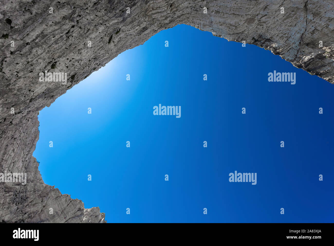 View from the bottom, visible along the edges of the cliff and blue sky ...