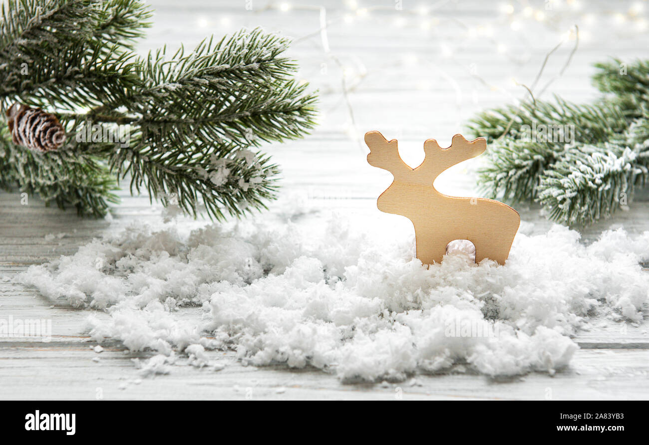 Christmas wooden deer with fir tree and snow on white wooden background ...