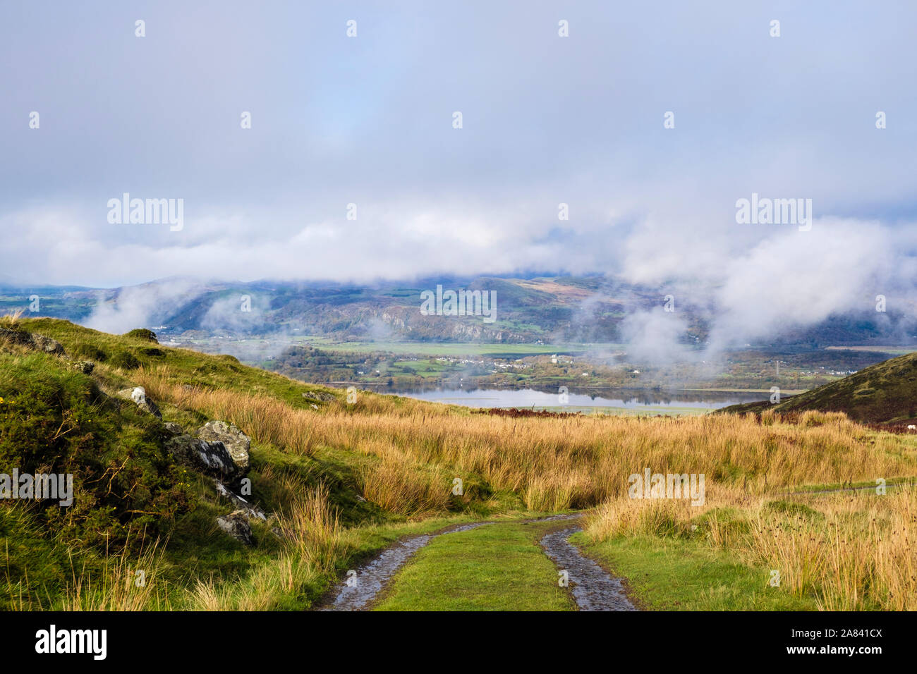 Farm track in Rhinog hills above Afon Dwyryd river estuary with low ...