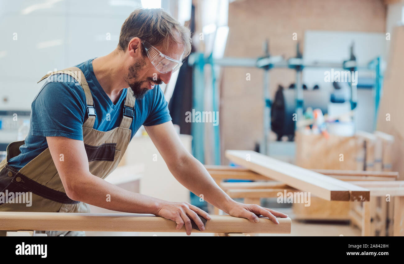 Carpenter sanding piece of wood by hand Stock Photo - Alamy