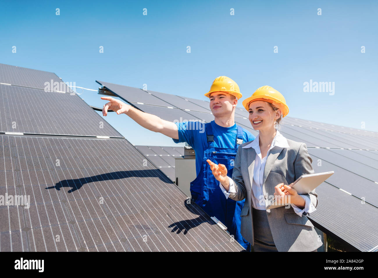 Worker and investor in solar power plant Stock Photo - Alamy
