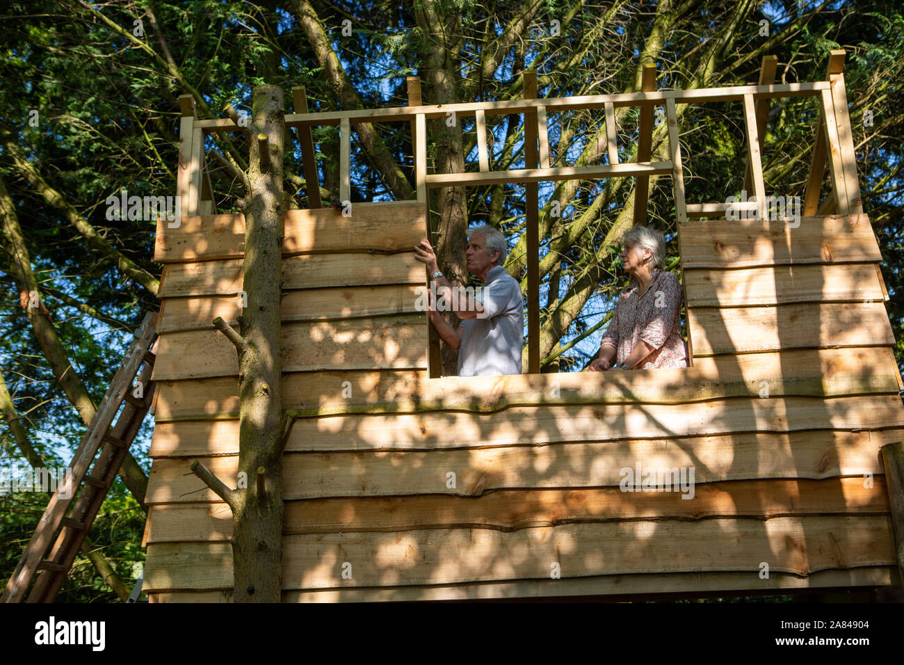 A family building a treehouse in their garden, England, UK Stock Photo ...