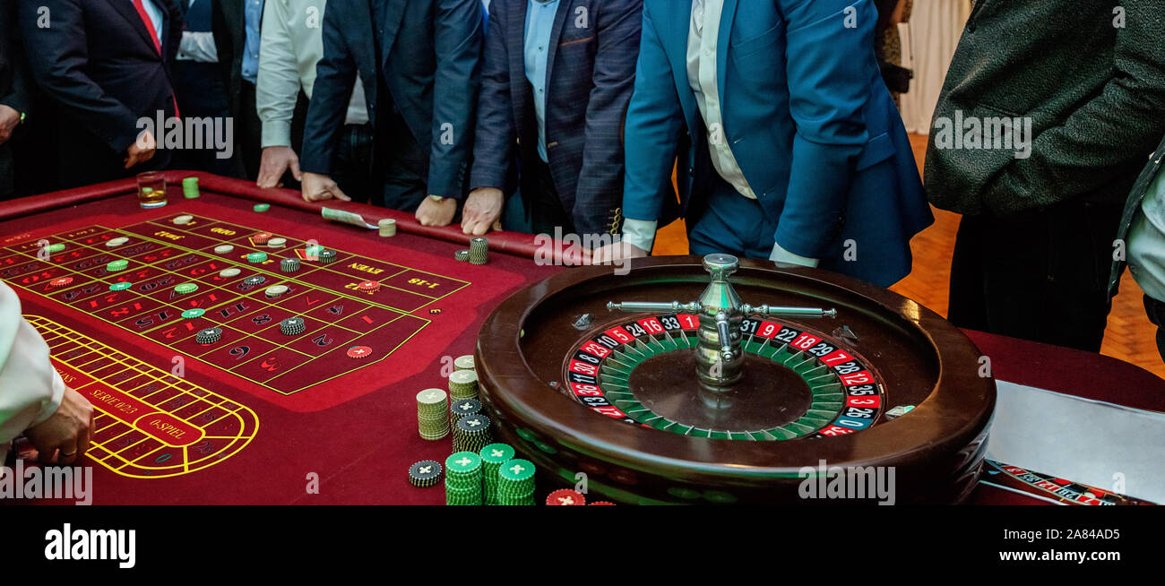Group of people behind roulette gambling table in luxury casino ...