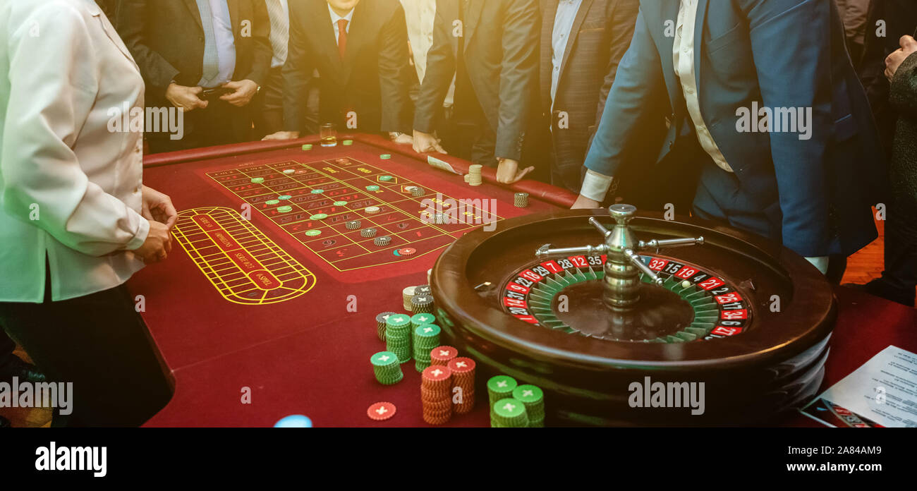 Group of people behind roulette gambling table in luxury casino ...