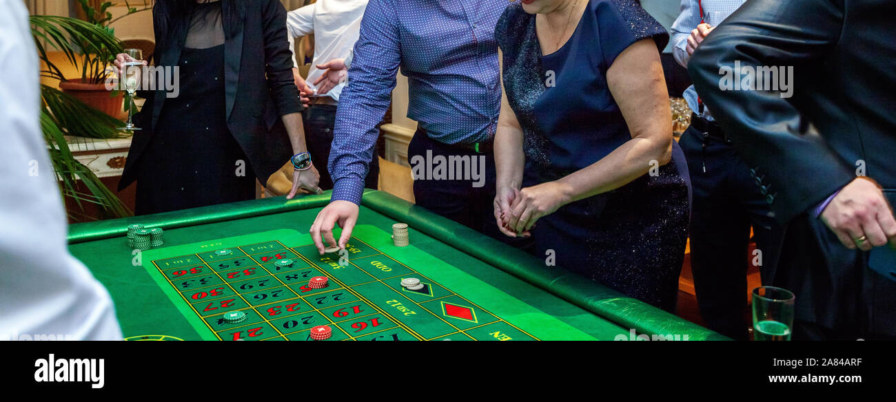 Group of people behind roulette gambling table in luxury casino ...