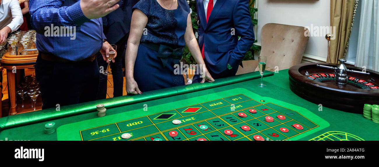 Group of people behind roulette gambling table in luxury casino ...