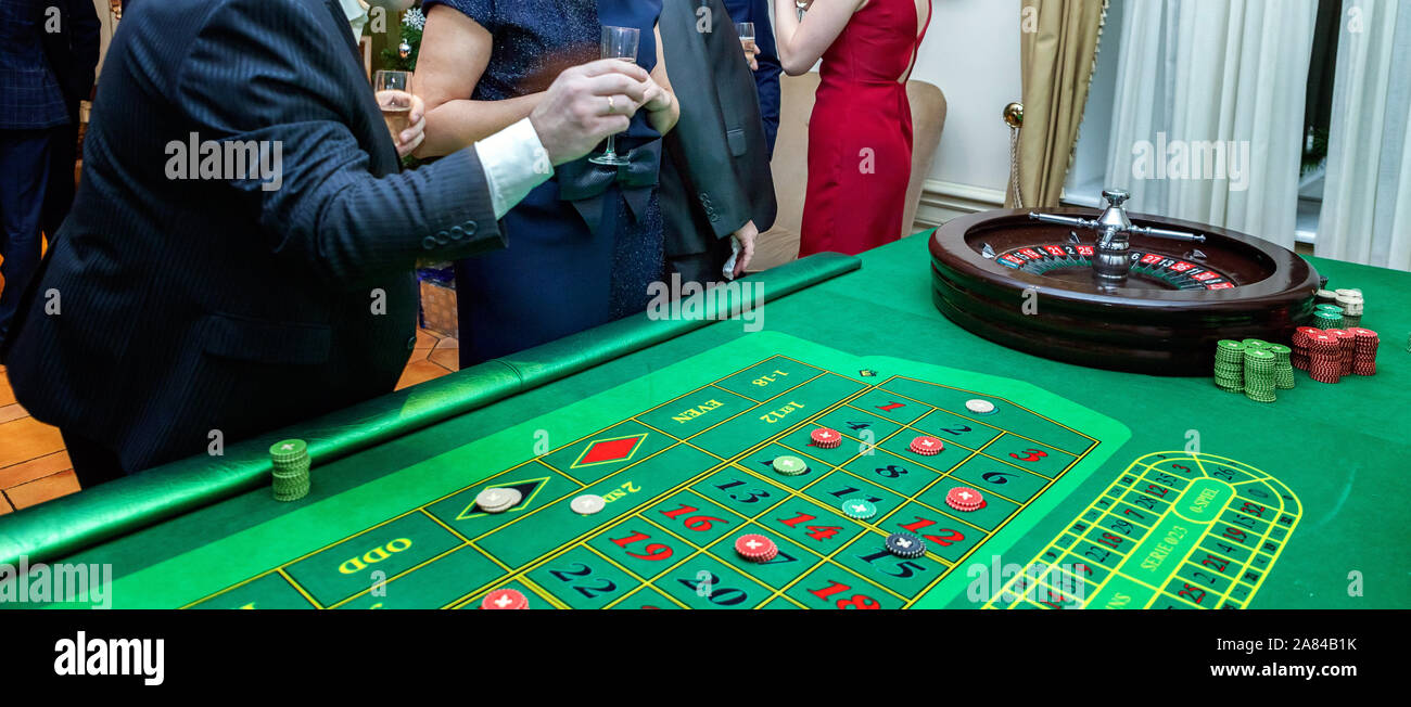 Group of people behind roulette gambling table in luxury casino ...