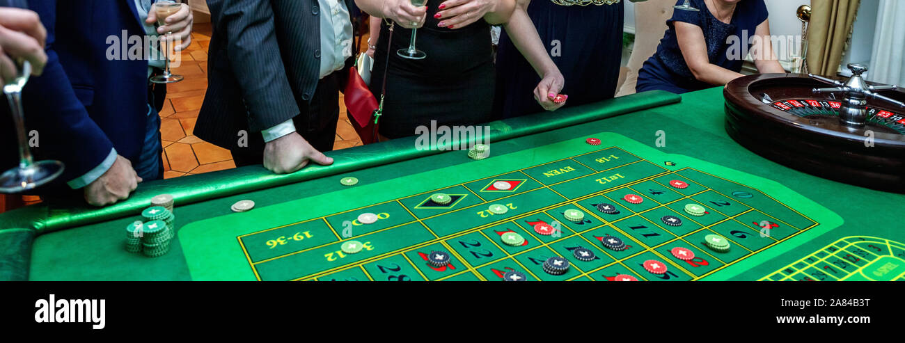 Group of people behind roulette gambling table in luxury casino ...