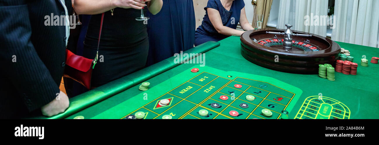 Group of people behind roulette gambling table in luxury casino ...