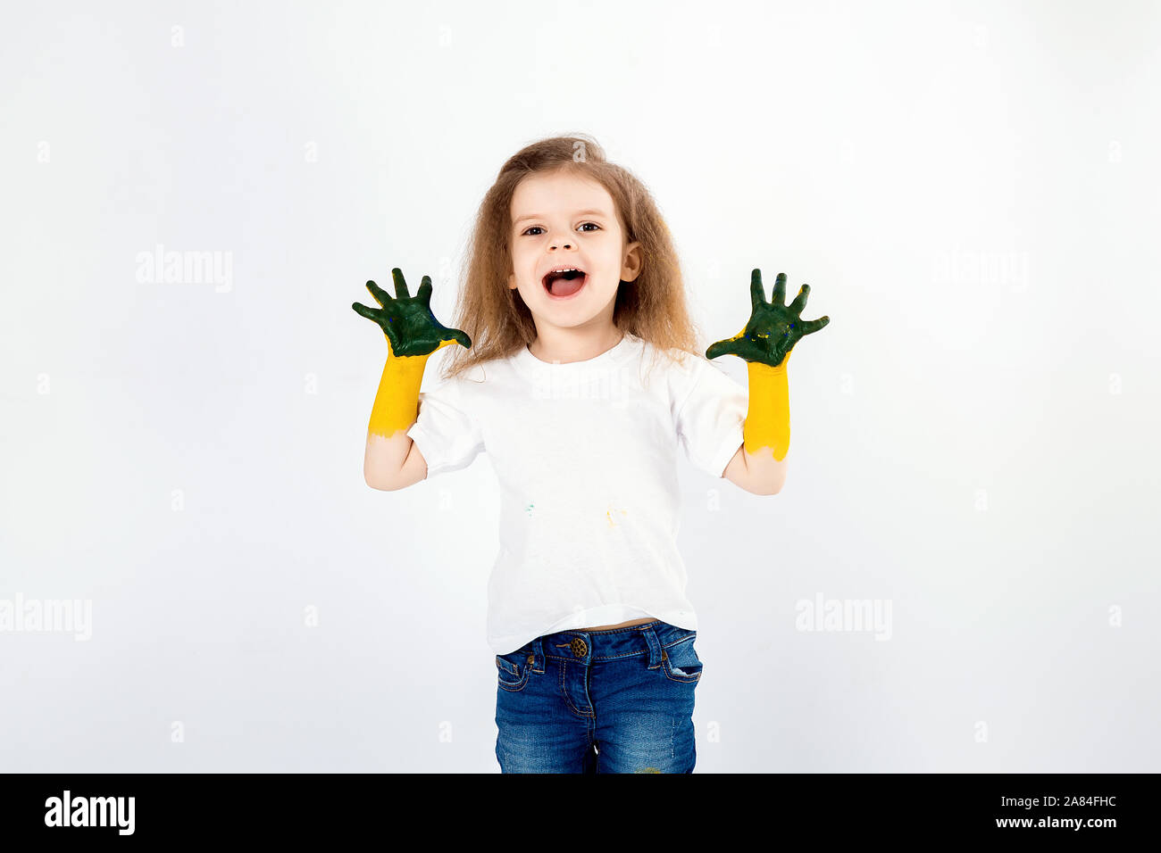 Adorable little girl, modern hair style, white shirt, blue jeans poses ...