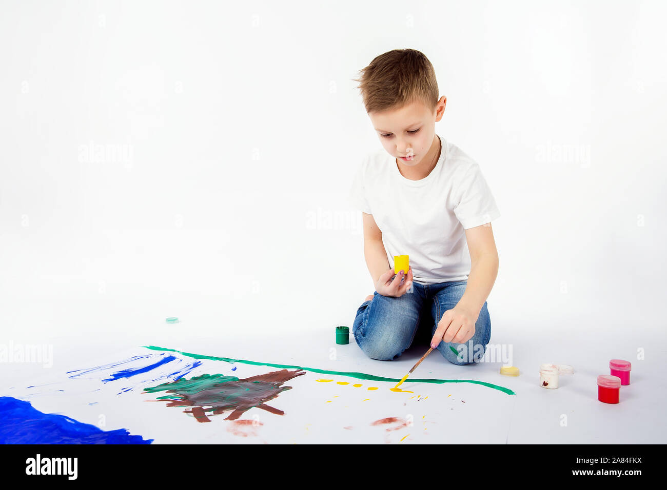 Child with paintbrush. 9 year Boy, modern hair style, white shirt, blue ...