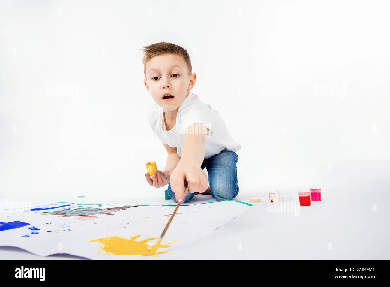 Child with paintbrush. 9 year Boy, modern hair style, white shirt, blue ...