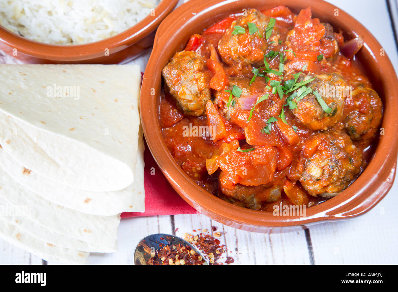 A traditional Turkish dish of baked meatballs in tomato and red pepper ...