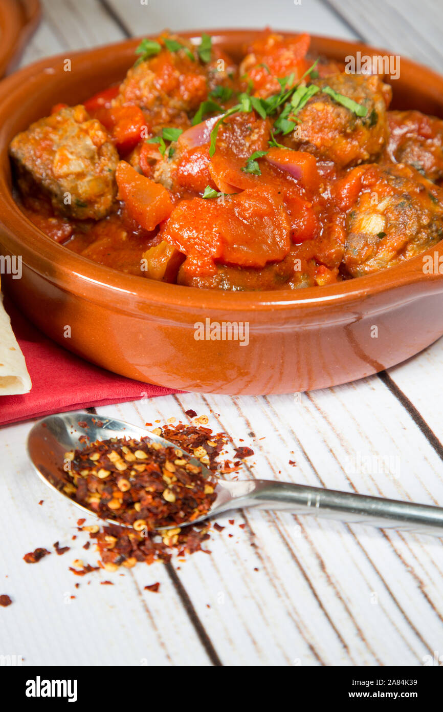A traditional Turkish dish of baked meatballs in tomato and red pepper ...