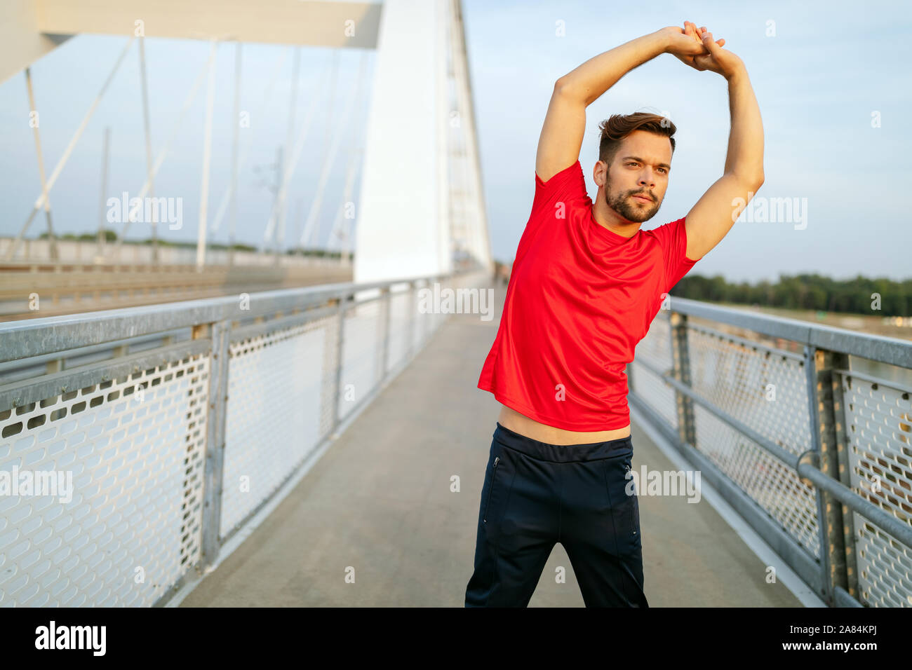 Beautiful male runner stretching before workout, fit man doing ...