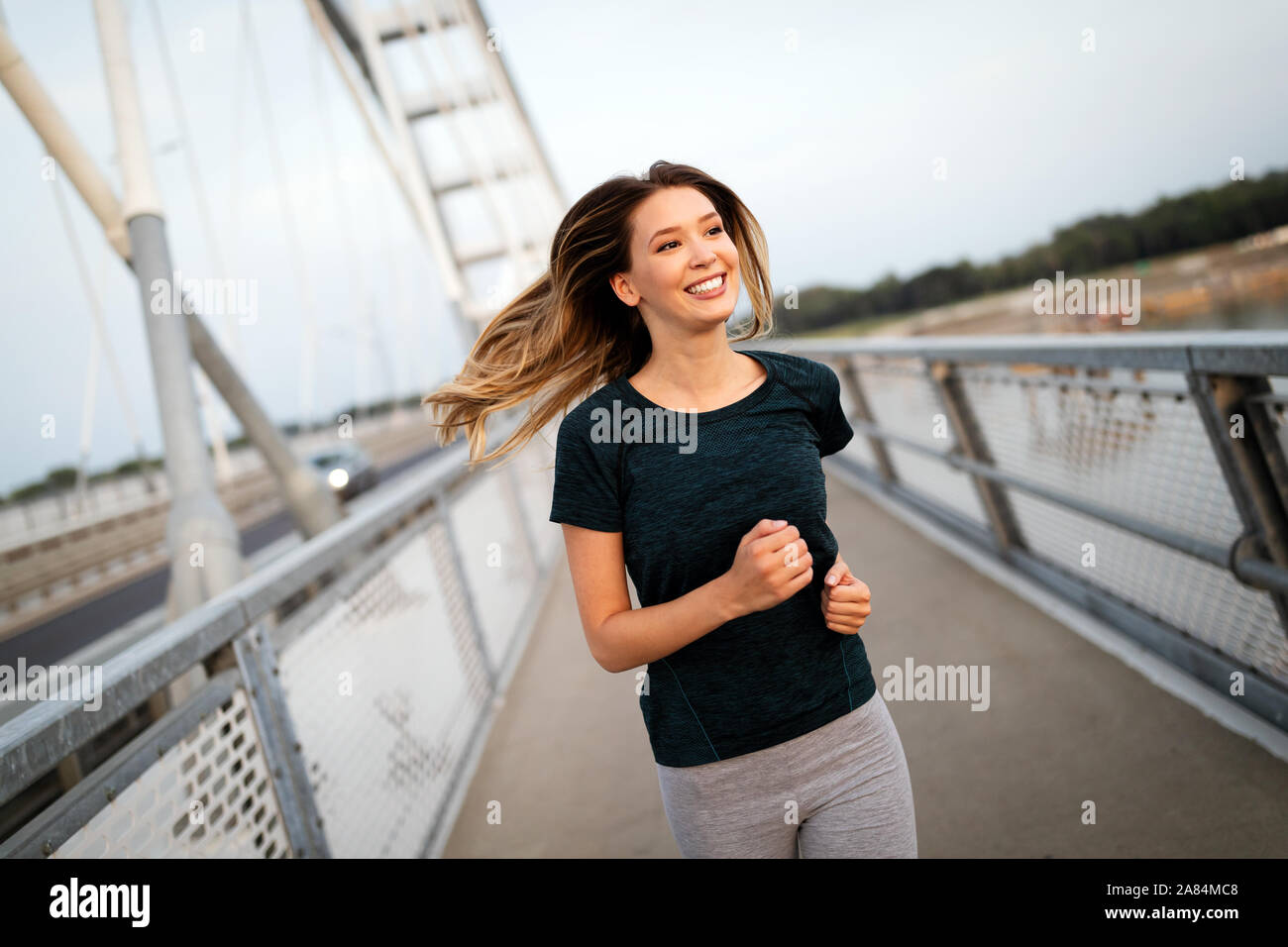 Portrait of fit and sporty young woman jogging outdoor Stock Photo - Alamy