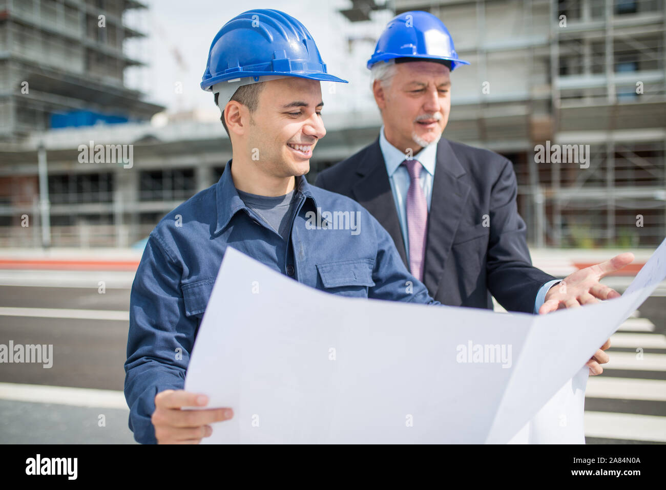Architect explaining what work to do to the site manager in front of a ...
