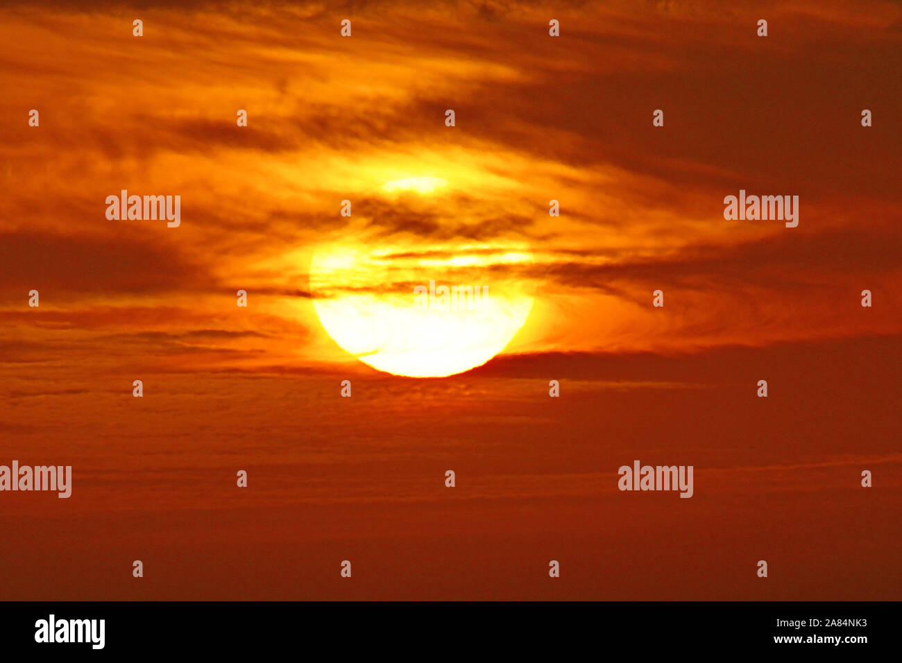 Dawn yellow sun with whirling red clouds Stock Photo - Alamy