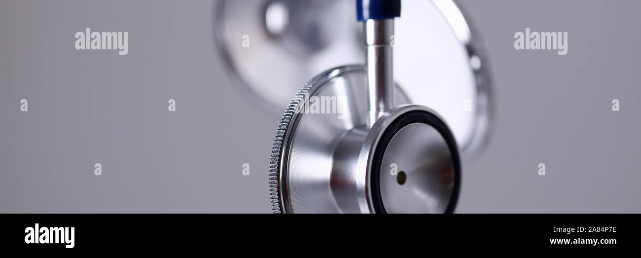 Stethoscope head lying on gray background closeup Stock Photo - Alamy