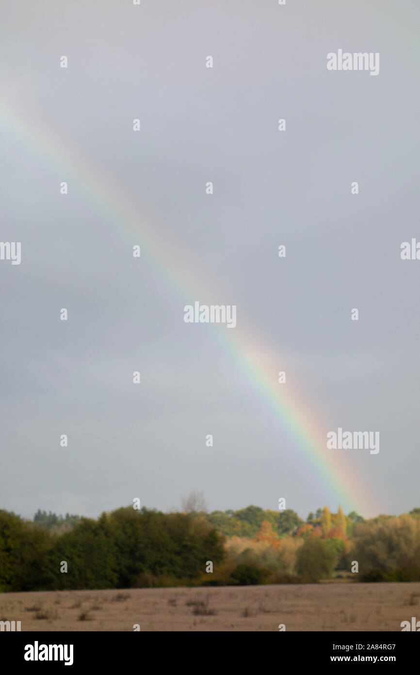 Rainbow over field Stock Photo - Alamy