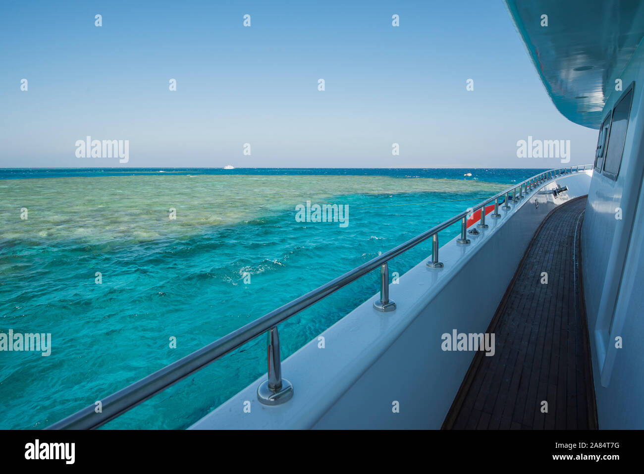 View down the side of the luxury motor yacht at sea with tropical ocen ...