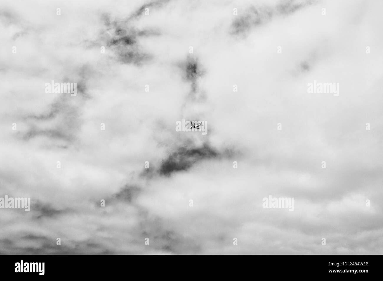 Airplane in the sky with clouds and sun Black and White Stock Photos ...