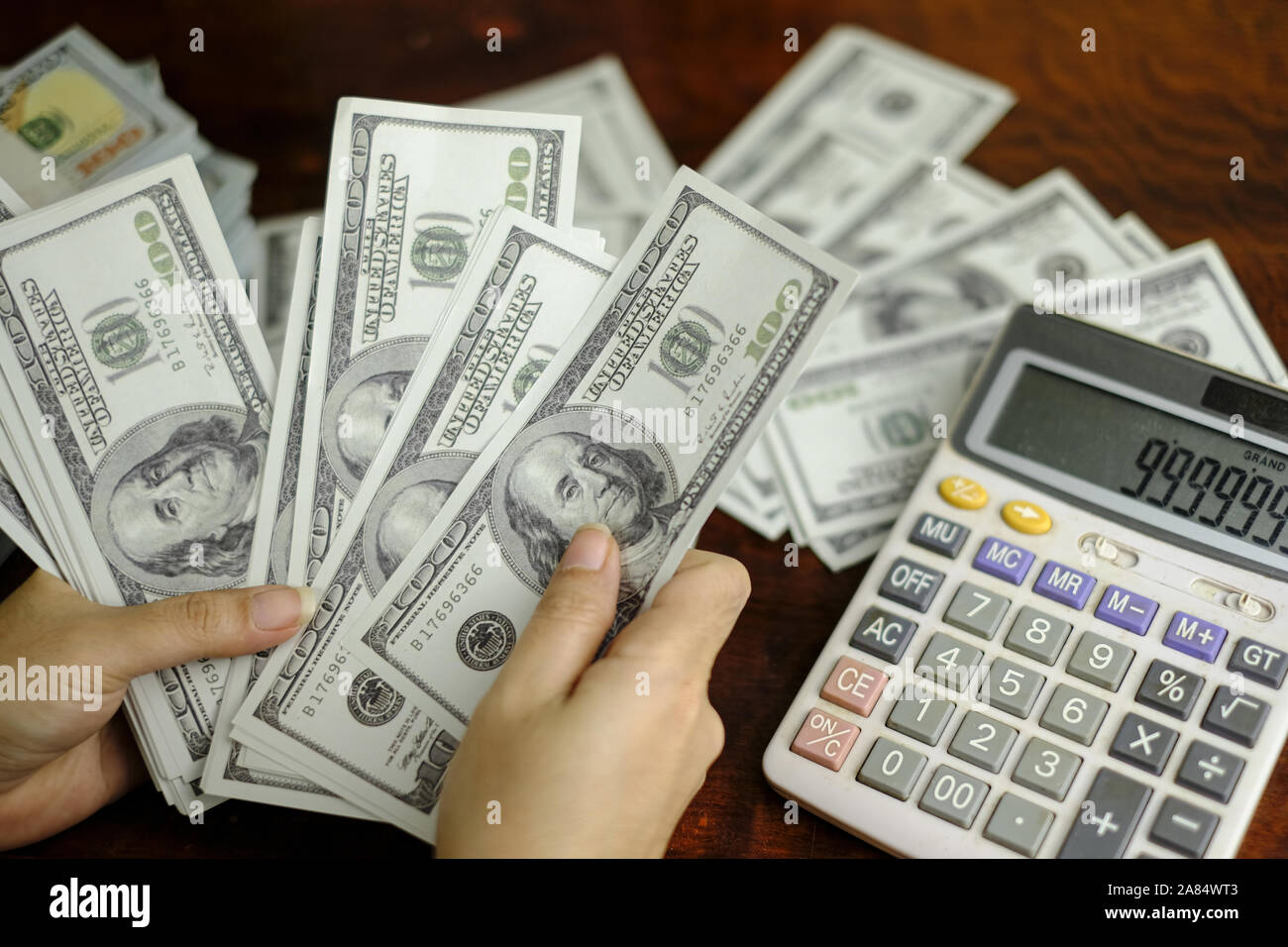 Businessmen women counting money on a stack of 100 US dollars banknotes ...