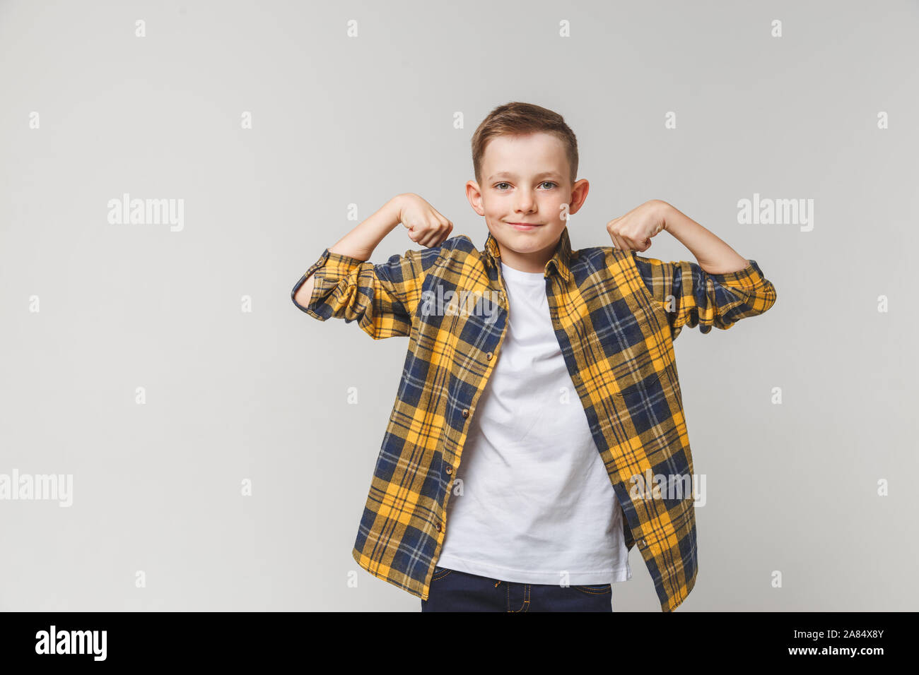 Positive teenage guy showing body strength Stock Photo - Alamy