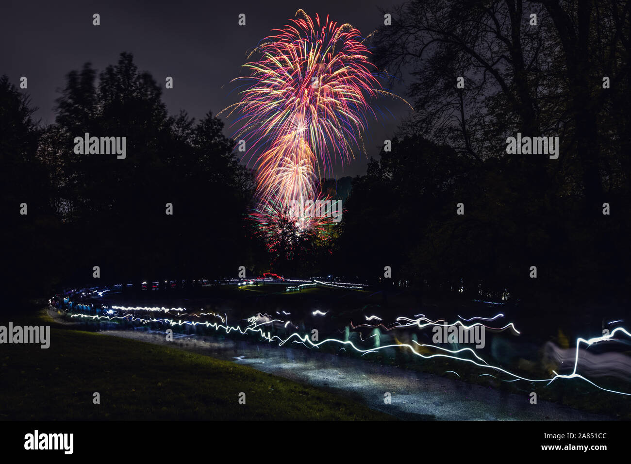 Light trails of people holding their phones and walking towards a ...