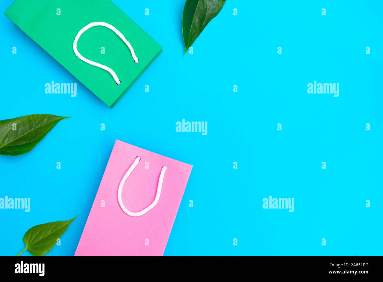 Flat lay with colorful paper bags on bright blue background Stock Photo ...