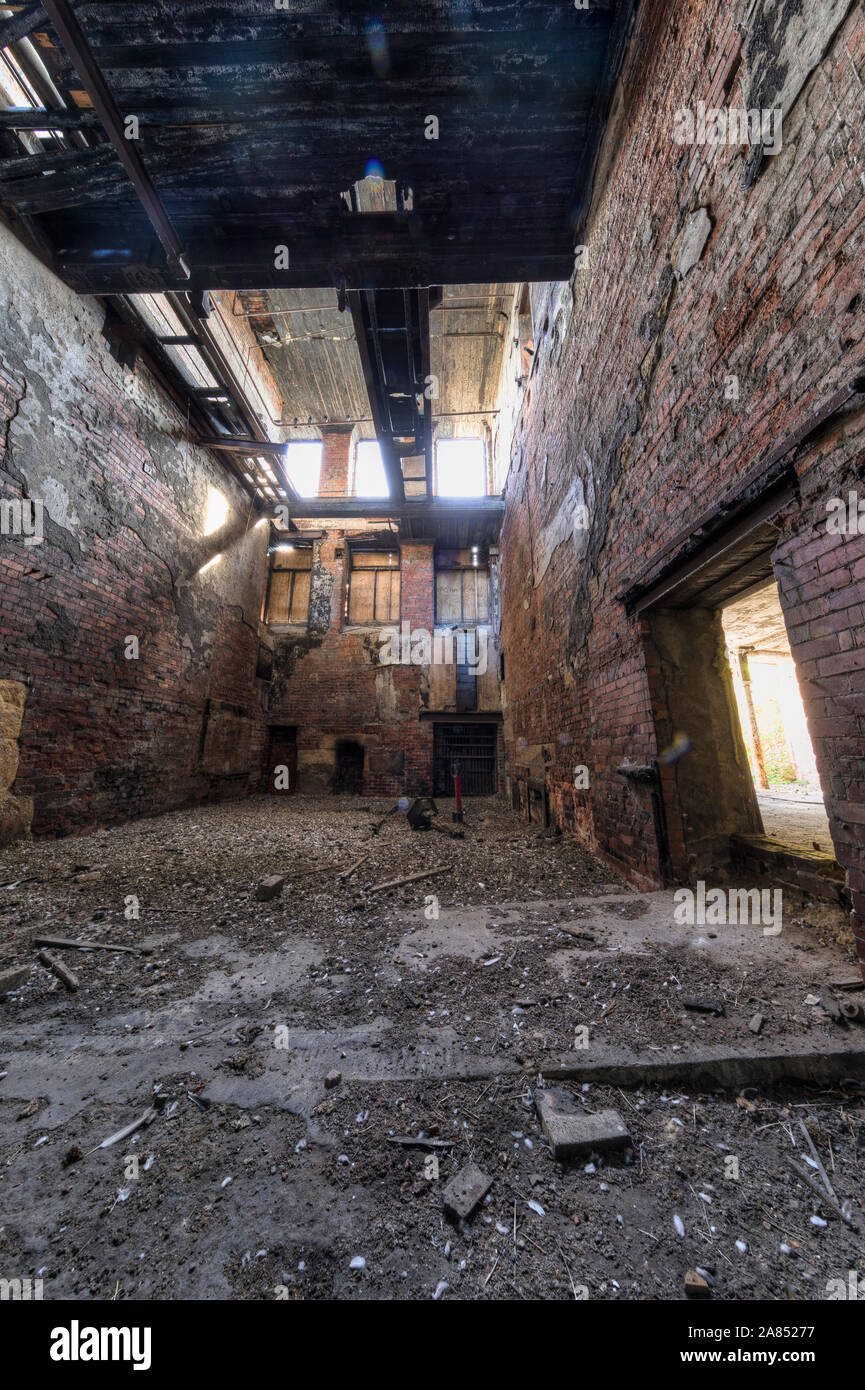 interior of derelict mill building with part of upper floor missing ...