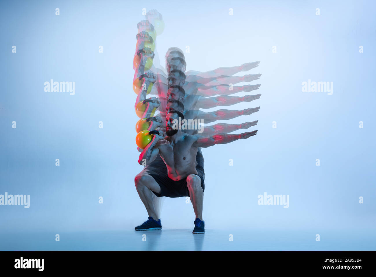 Balance. Young caucasian bodybuilder training over studio background in ...