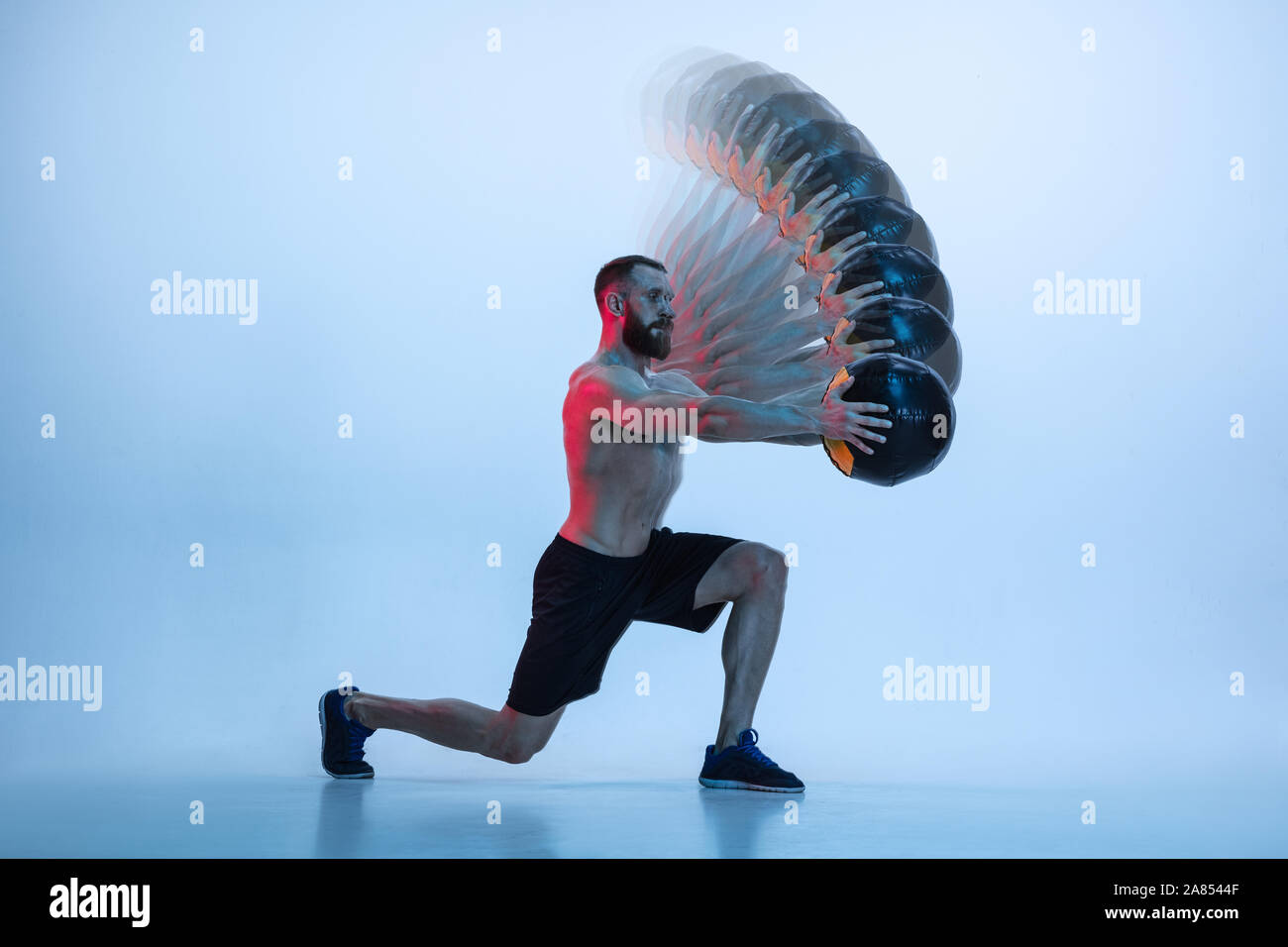 Flexible. Young caucasian bodybuilder training over studio background ...